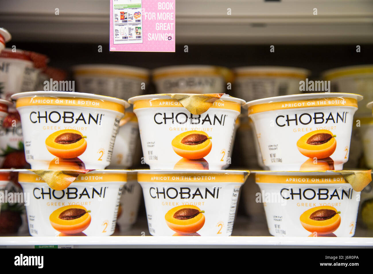 packages of Chobani brand yogurt on the shelves of a refrigerator case ...