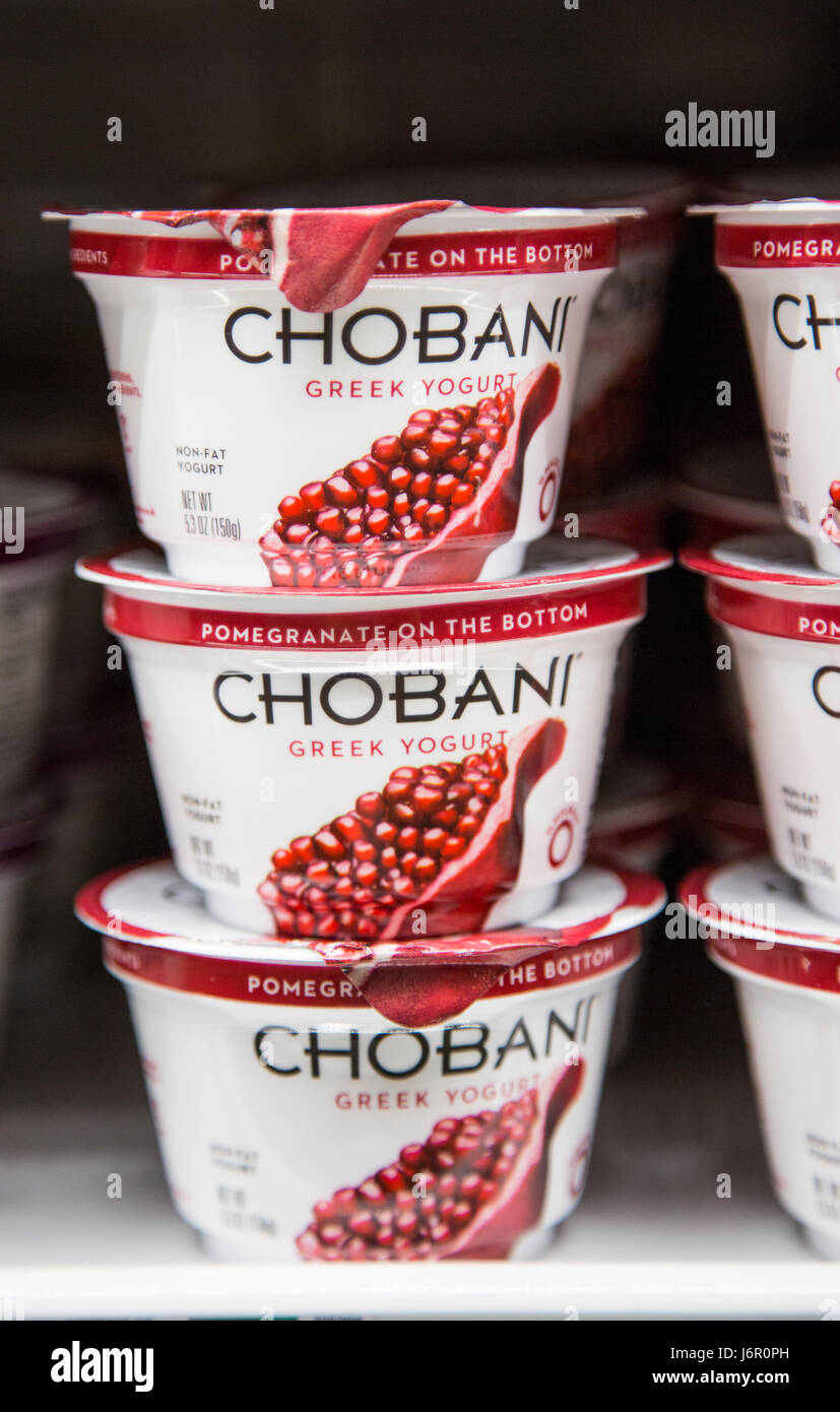packages of Chobani brand yogurt on the shelves of a refrigerator case ...