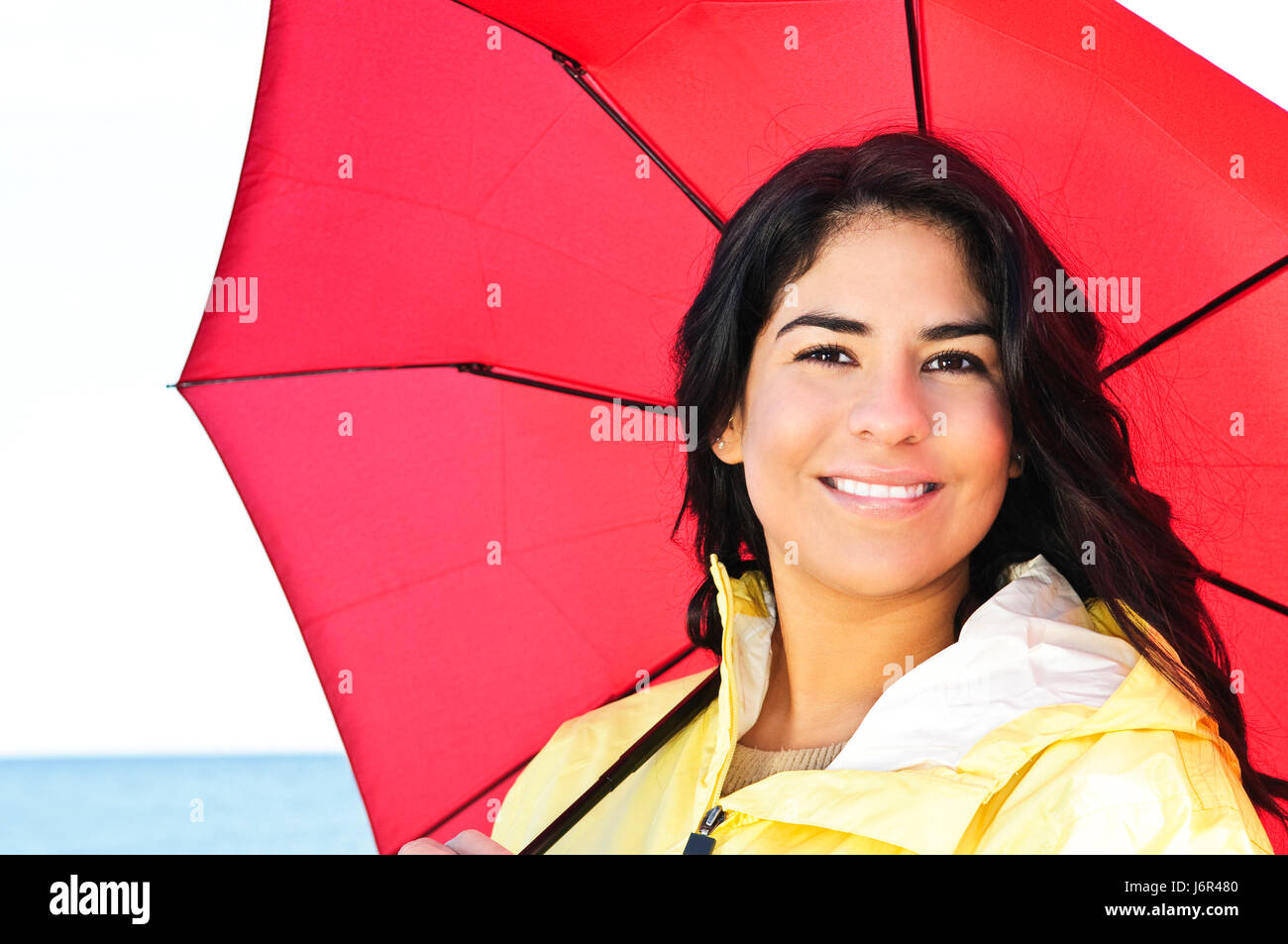 woman umbrella rain raincoat red girl girls yellow raining laugh laughs ...