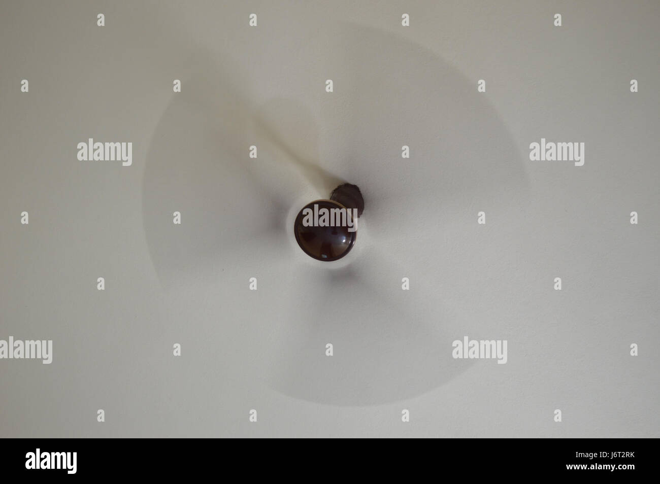 This image captures a rotating ceiling fan with a 1/20th-second shutter ...
