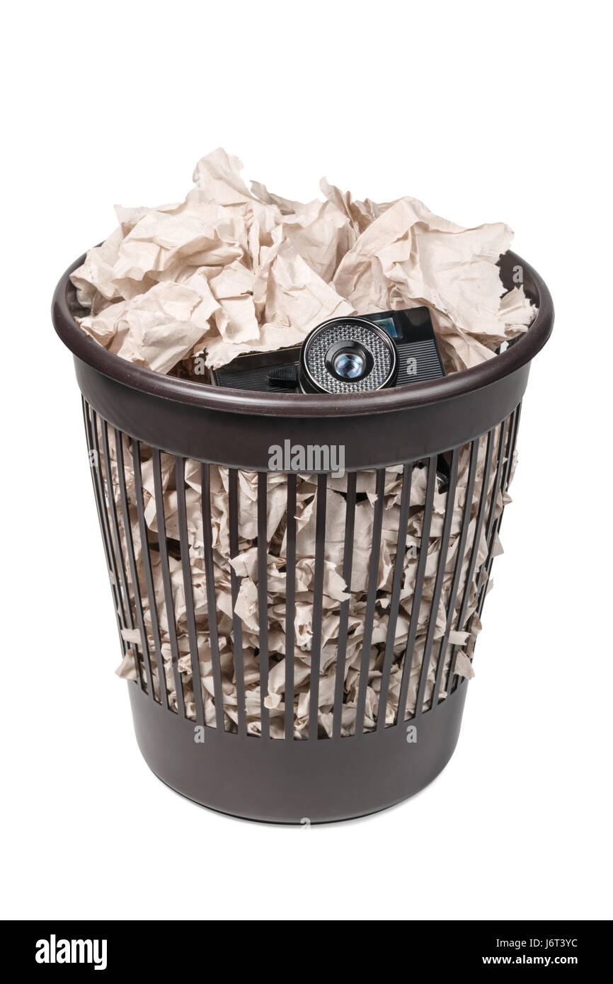 Old film camera in a trash can full of paper, isolated on a white ...