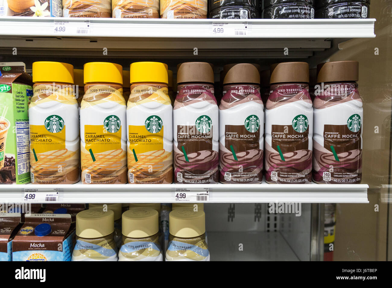 a row of Starbucks brand coffee drinks on a shelf in the refrigerator ...