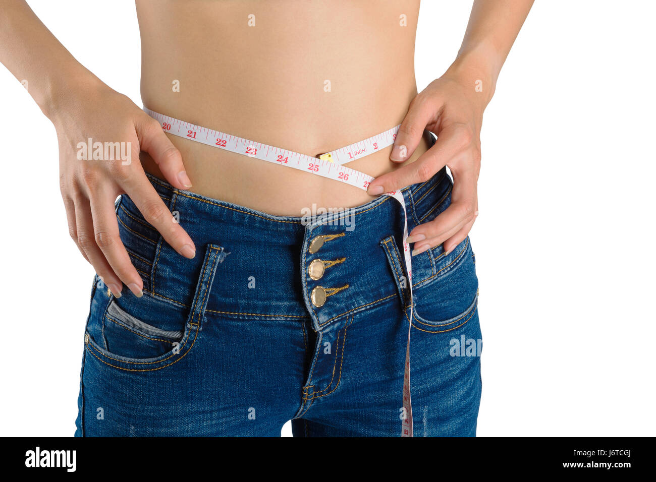 Woman on white in blue jeans tape measure her waist and hips with ...