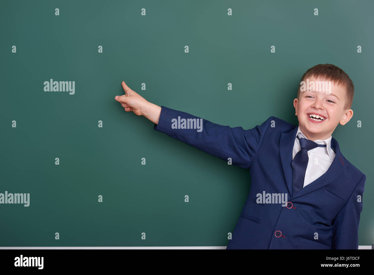 school boy point the finger near blank chalkboard background, dressed ...