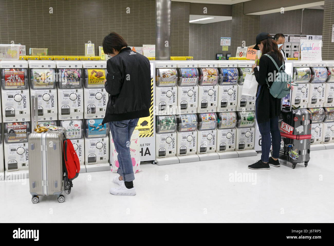 Passengers look at the capsule toy vending machines (Gacha Gacha) at ...