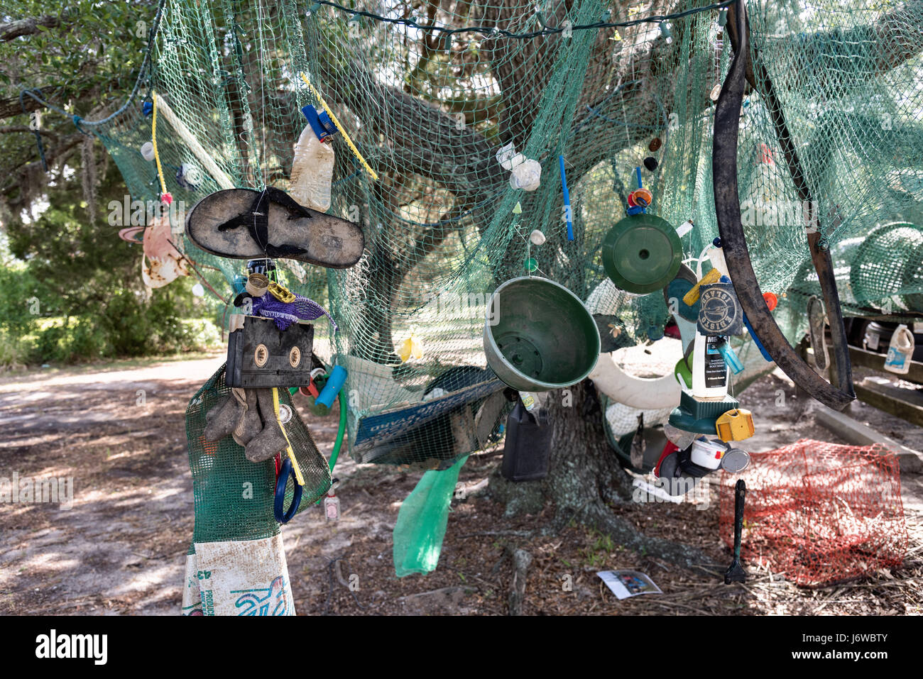A sculpture made from waste and trash washed up in Jeremy Creek hangs ...