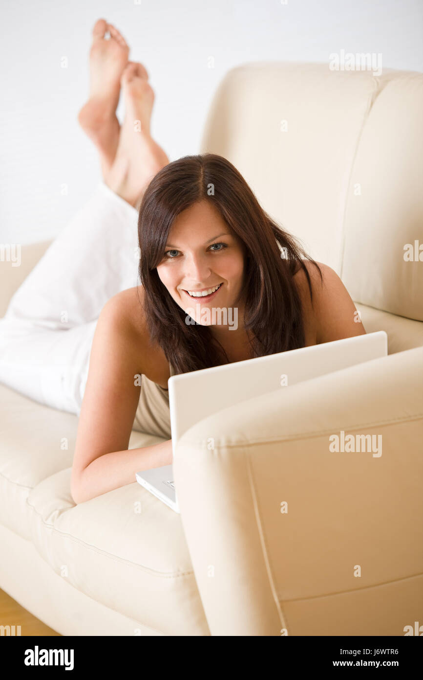woman laptop notebook computers computer relaxation sofa lounge delighted Stock Photo - Alamy