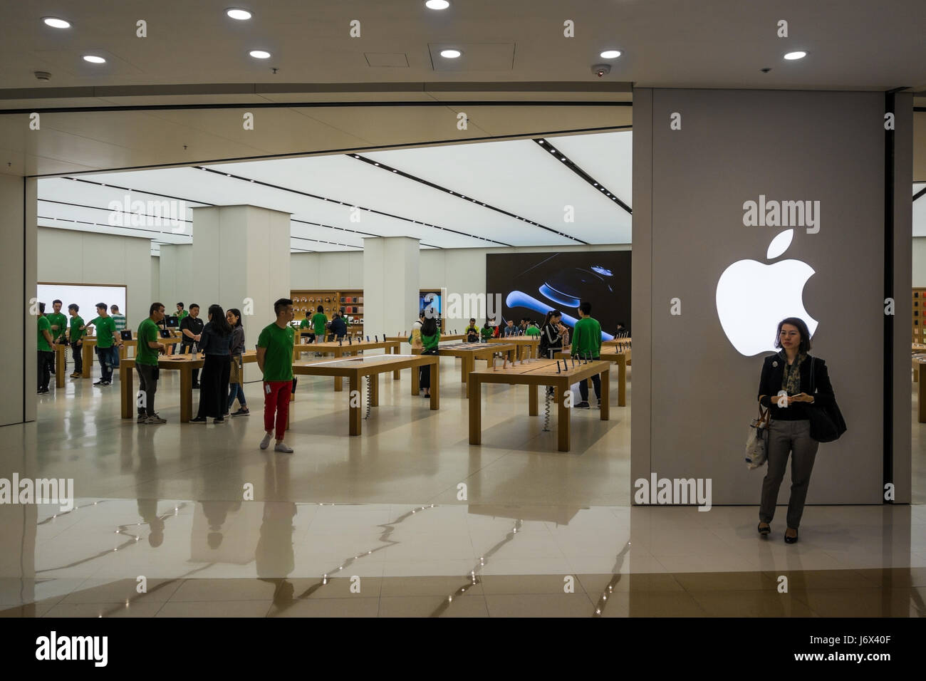 Apple Store in Hong Kong and woman standing in front of Apple logo ...