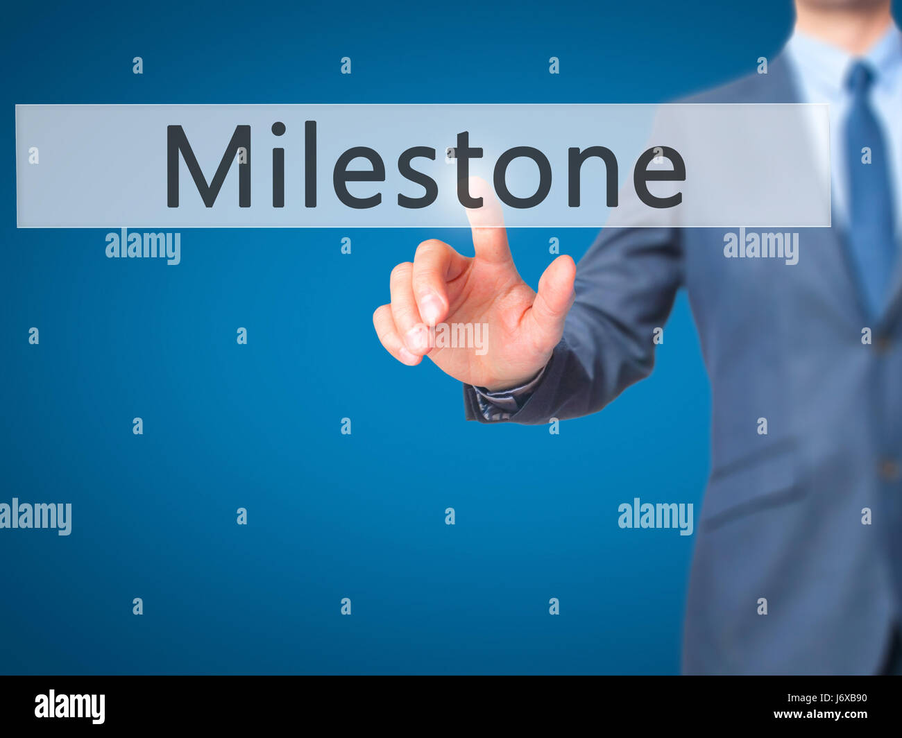 Milestone - Businessman hand pressing button on touch screen interface ...