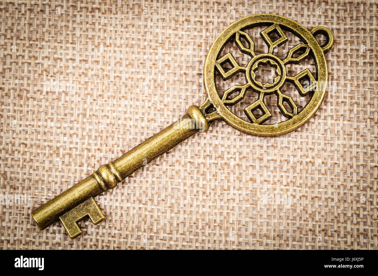Key vintage metal on burlap background Stock Photo - Alamy