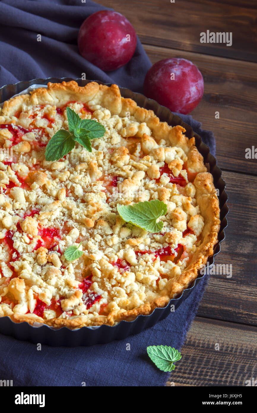 Homemade shortcrust plum cake (pie) with crumble on wooden background ...
