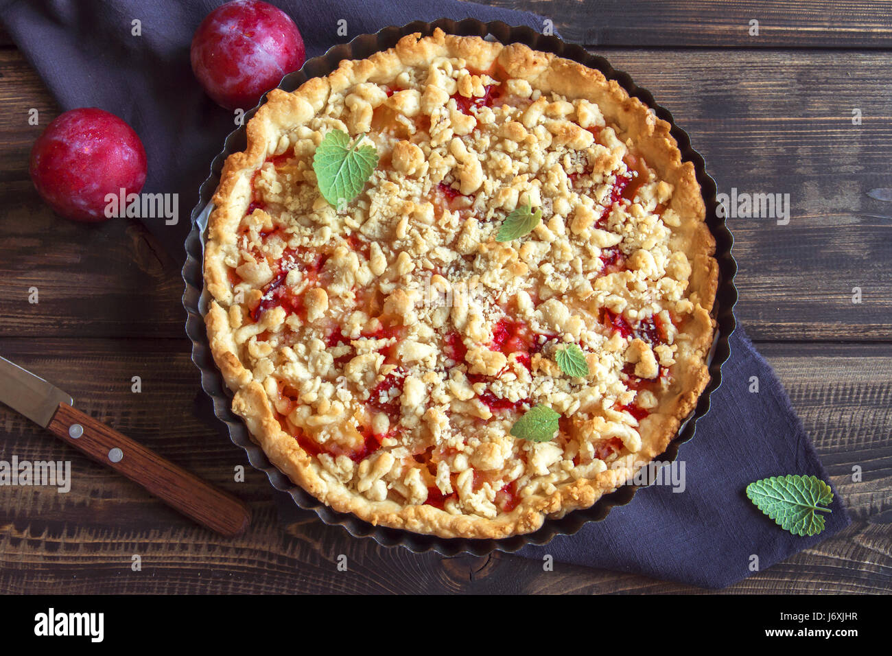 Homemade shortcrust plum cake (pie) with crumble on wooden background ...