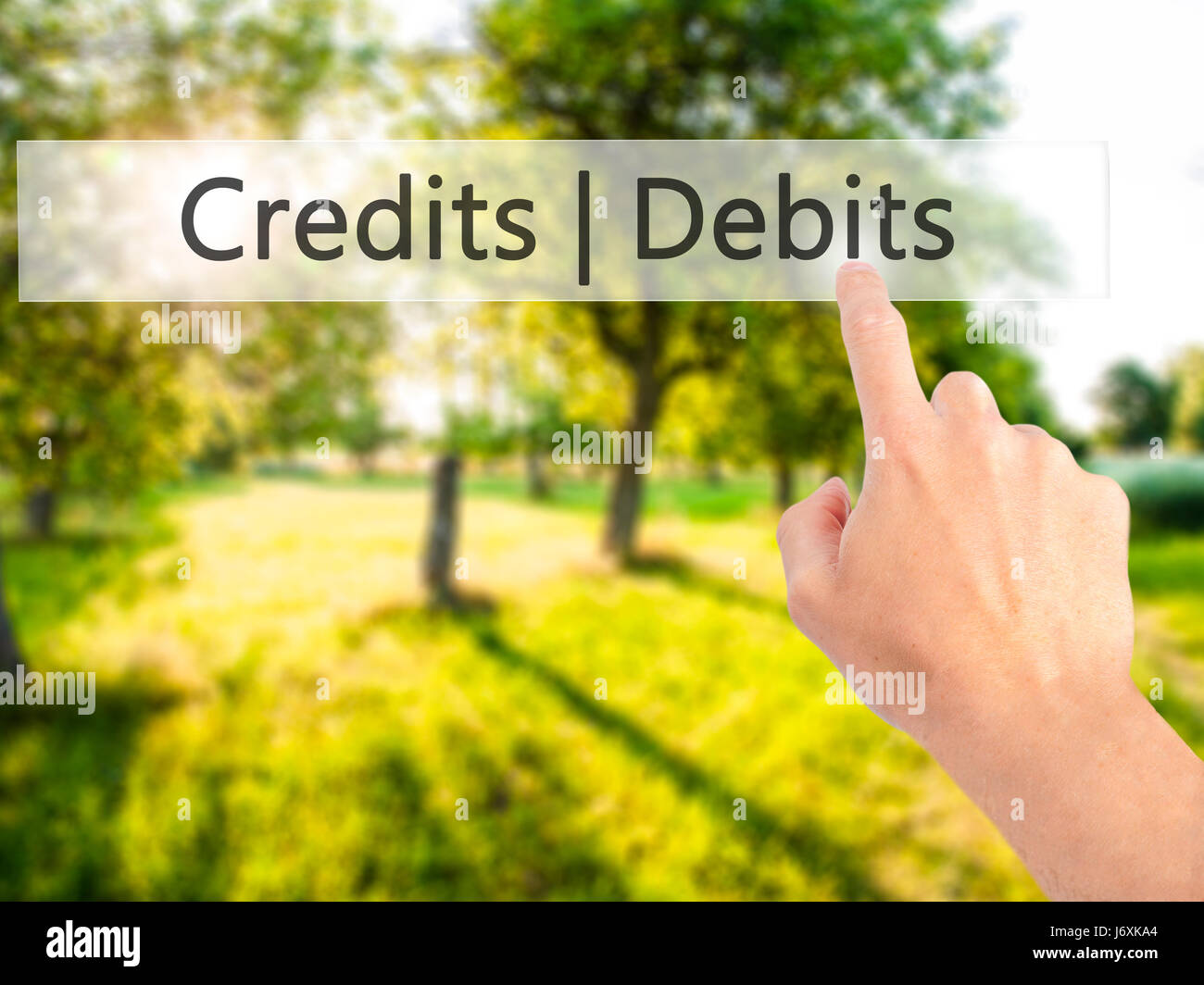 Credits Debits - Hand pressing a button on blurred background concept ...