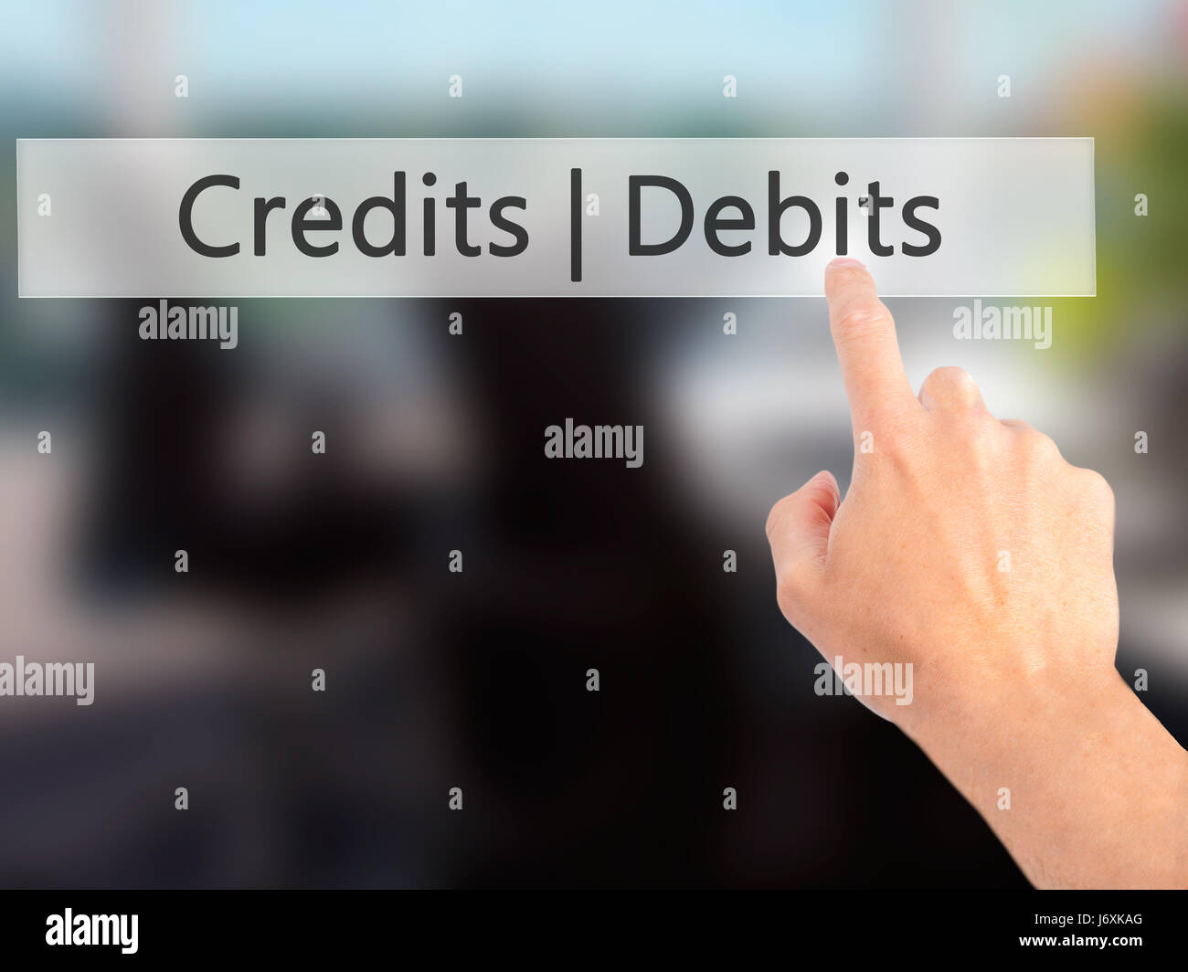 Credits Debits - Hand pressing a button on blurred background concept ...