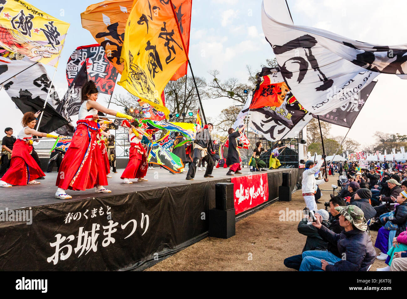 Yosakoi dancers in red and white costumes, dancing on stage while ...