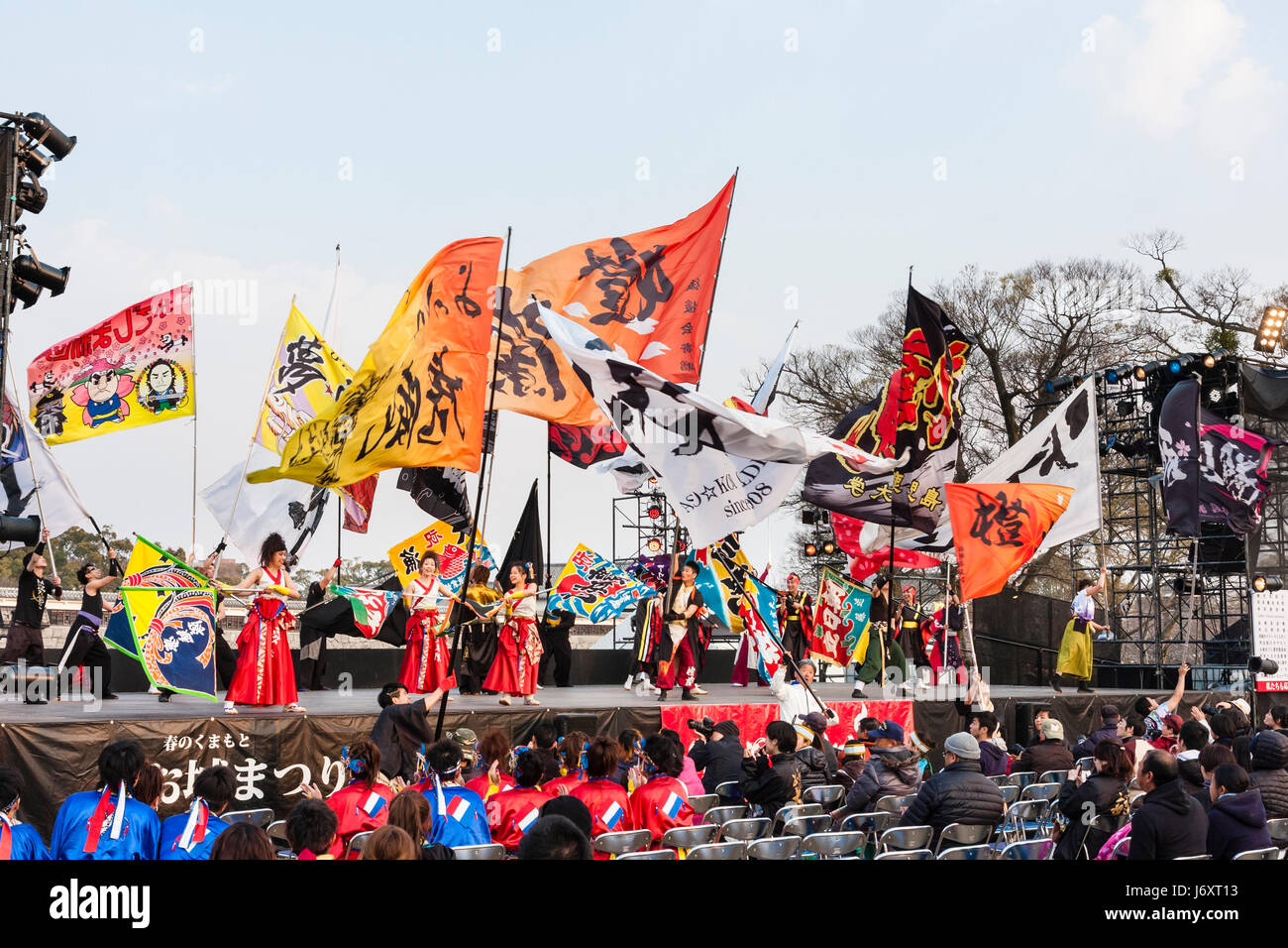 Yosakoi dancers in red and white costumes, dancing on stage while ...