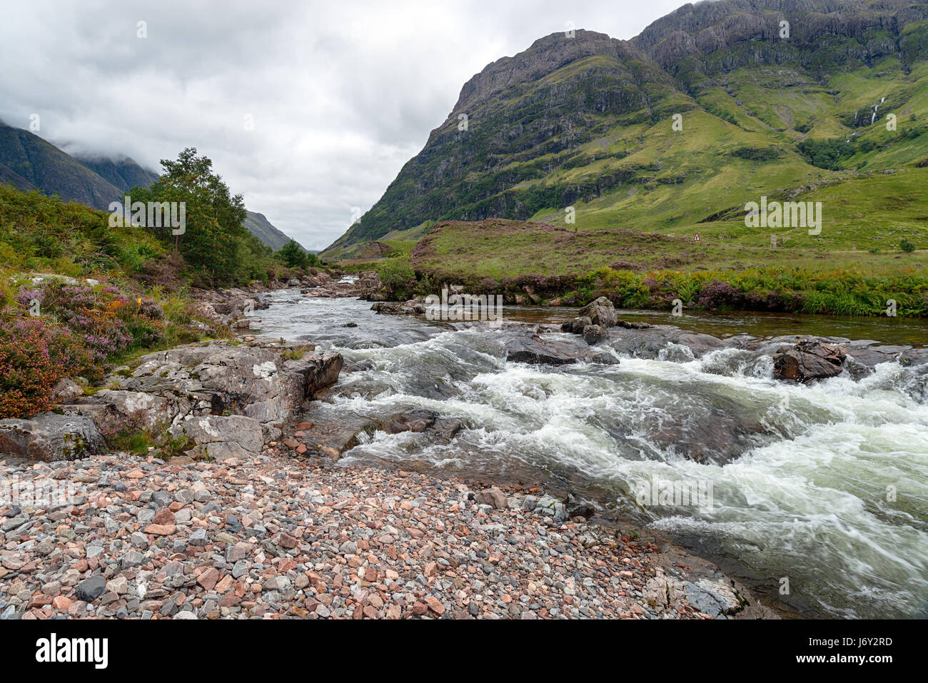 The river Coe flowing through the valley below mountains at Glencoe in ...