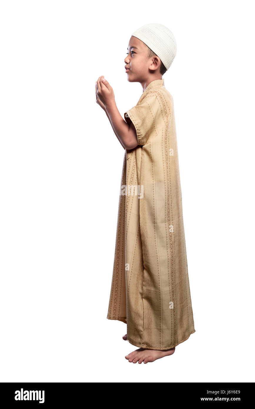 Little asian muslim kid in traditional dress with cap praying isolated ...