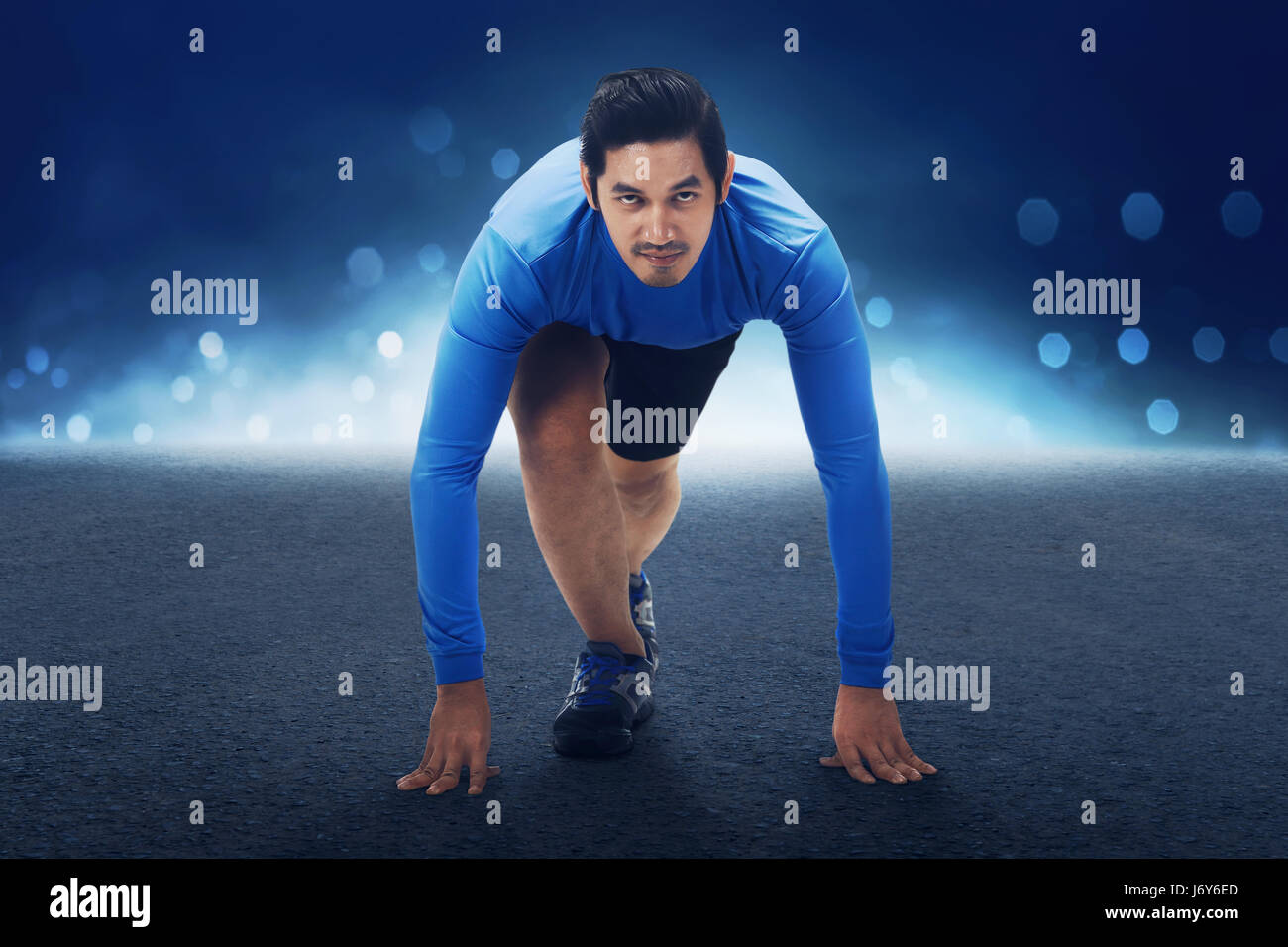 Runner asian man with hands on starting line ready to sprint on ...