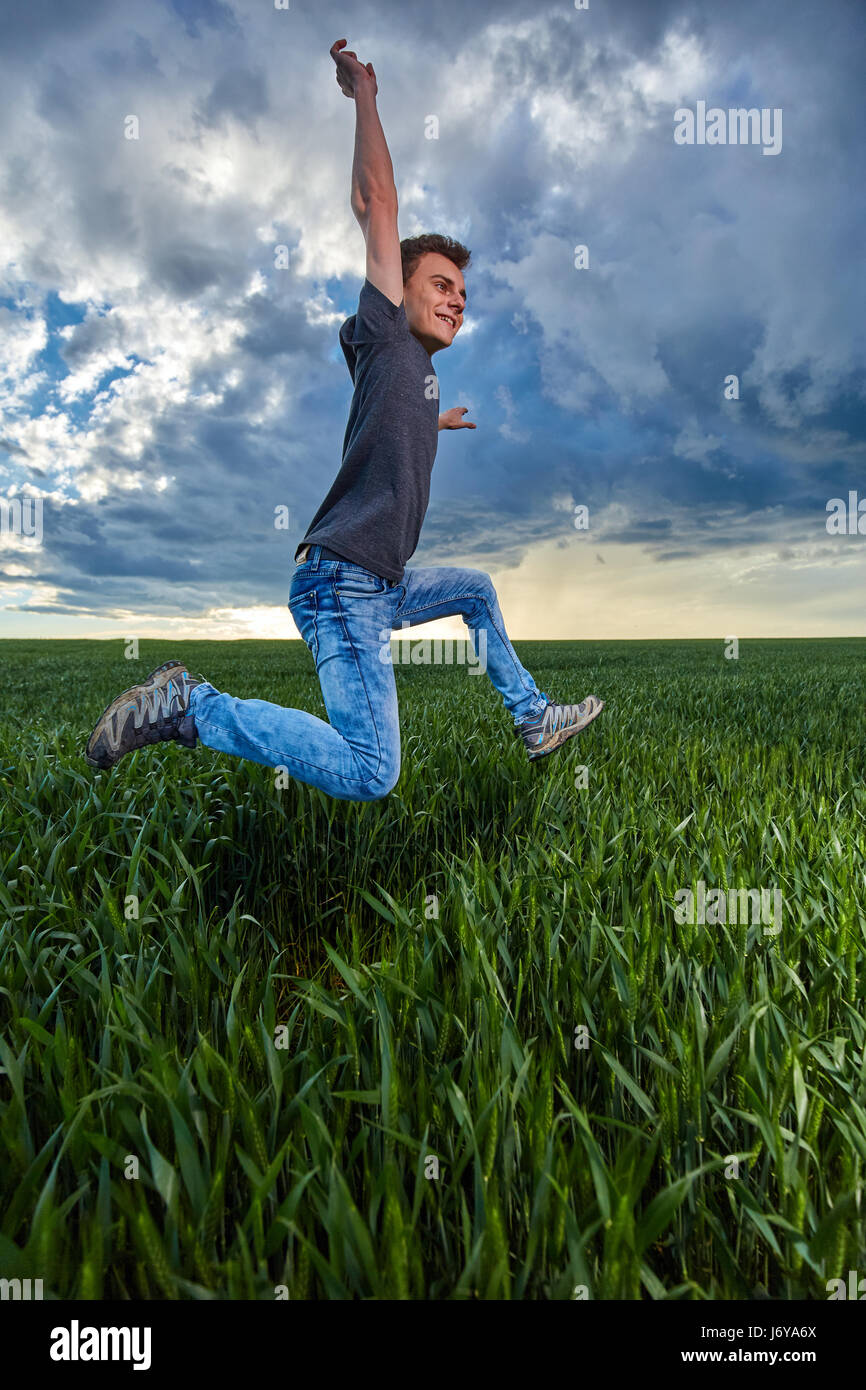Teenage farmer boy jumping for joy in a wheat field Stock Photo - Alamy