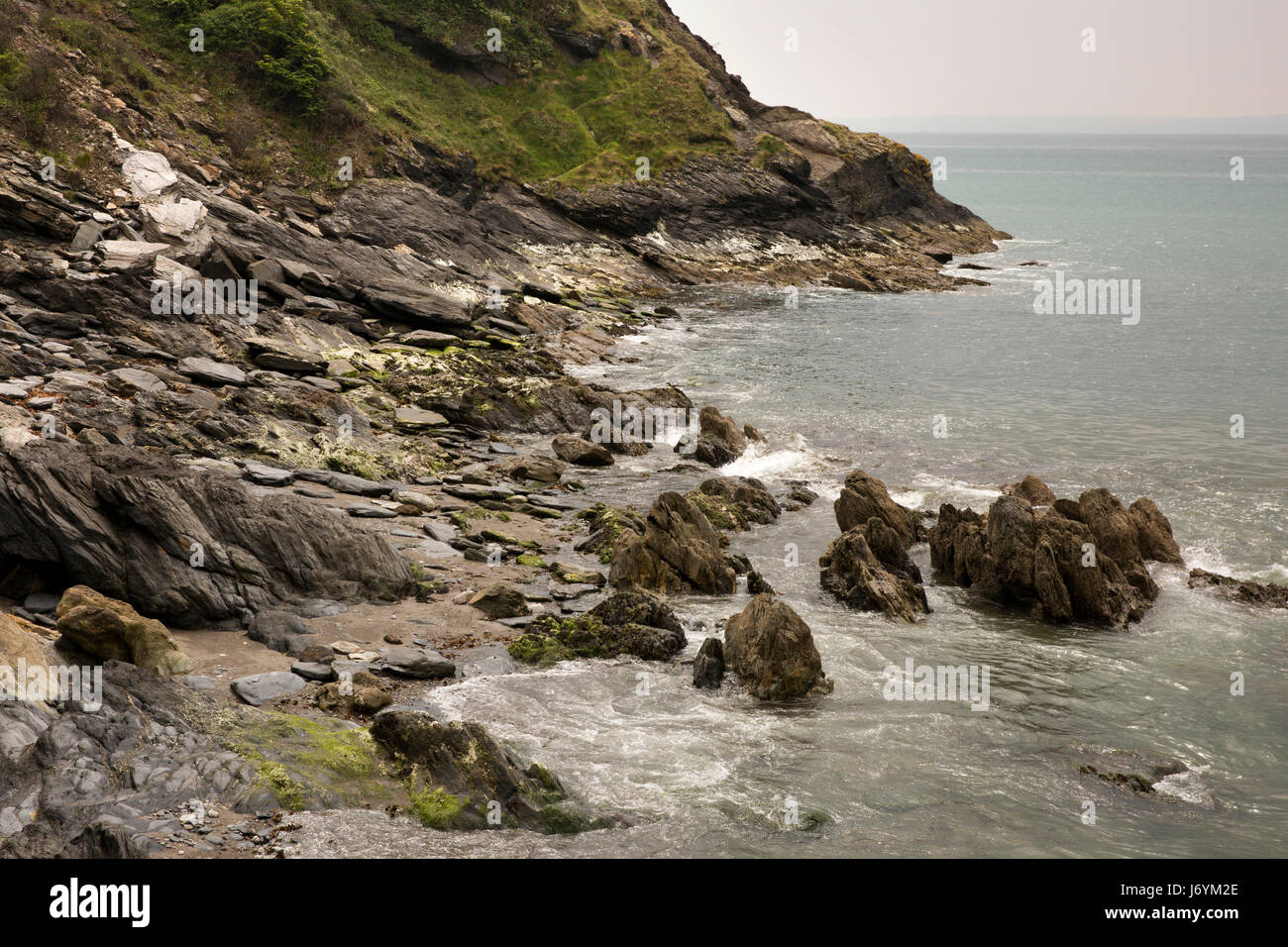 UK, Cornwall, St Austell, Polkerris, waves breaking on rocky shore ...