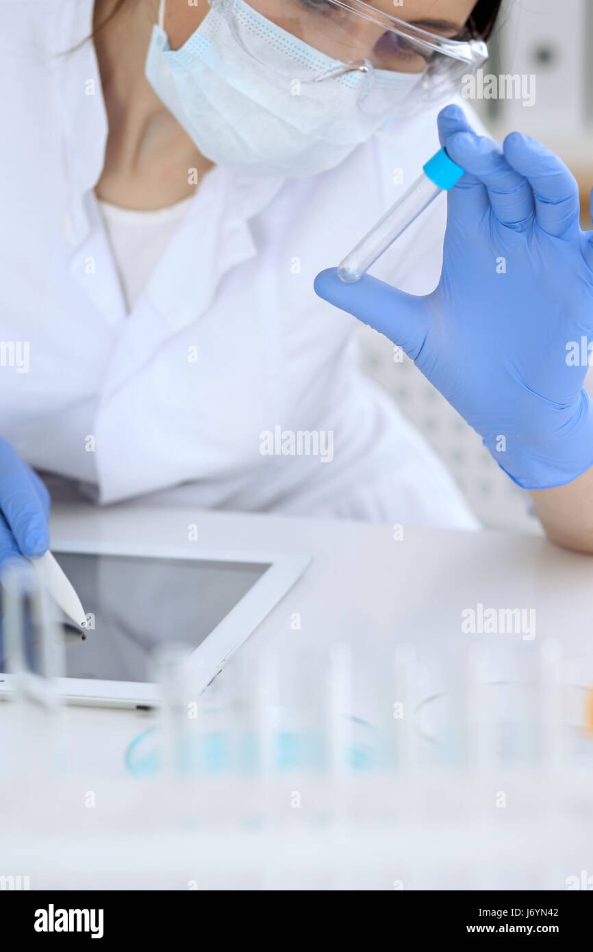 Close up of scientific research hands with clear solution in laboratory ...