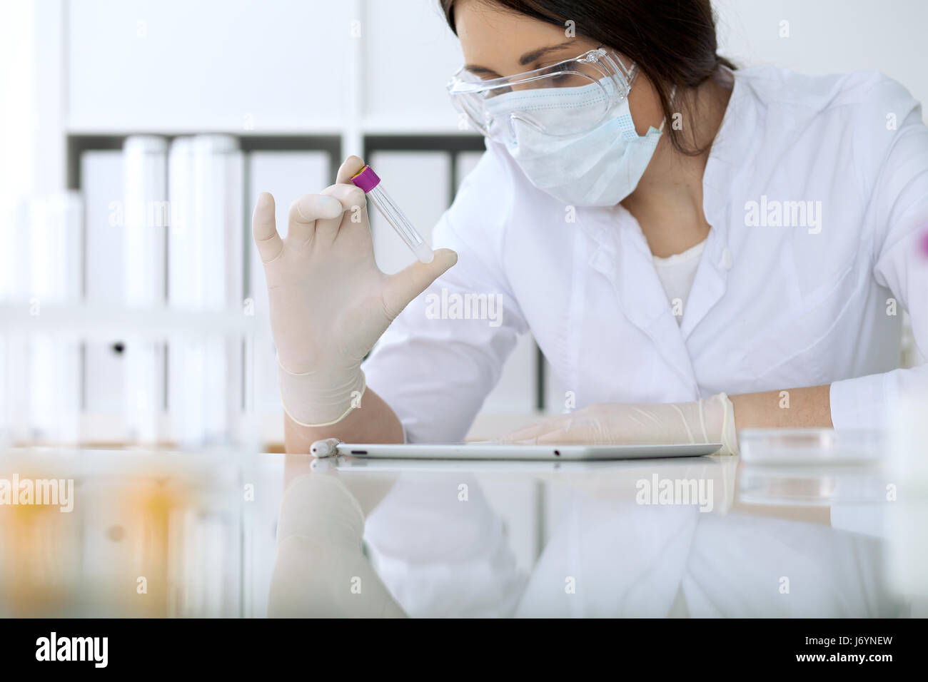 Close up of scientific research hands with clear solution in laboratory ...