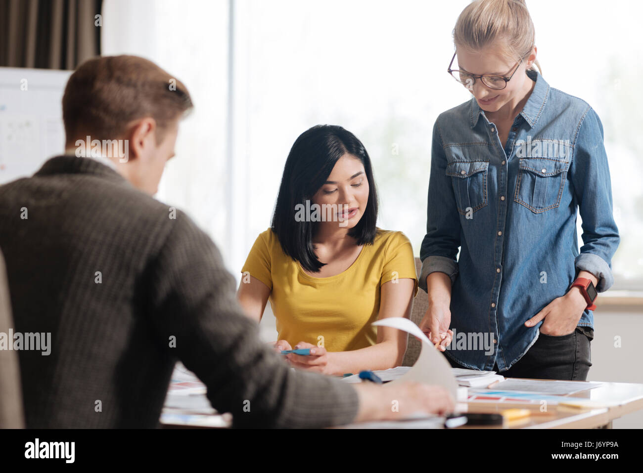Nice pleasant woman standing near her colleague Stock Photo - Alamy