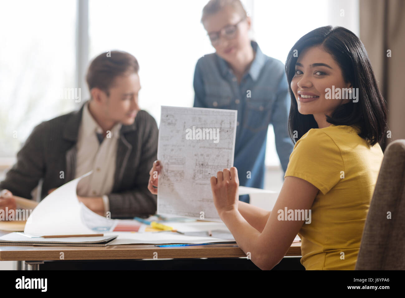 Joyful positive woman holding an engineering drawing Stock Photo - Alamy
