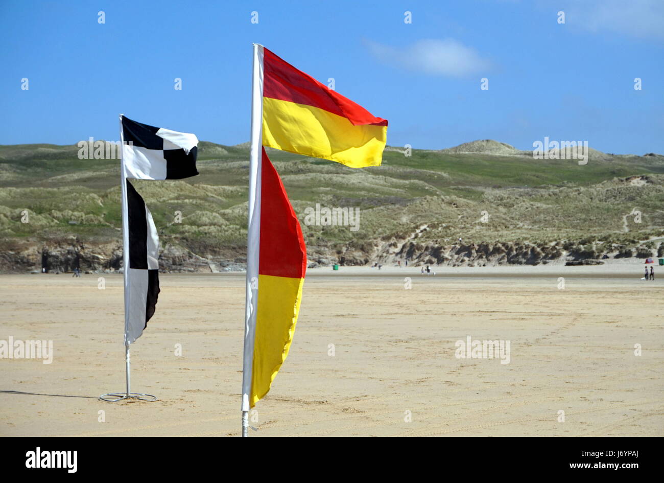 Flags on a deserted beach indicating safe swimming and surfing zones ...
