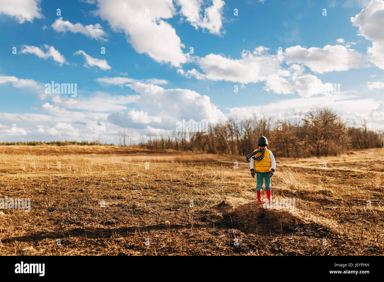 Boy standing in rural landscape Stock Photo - Alamy