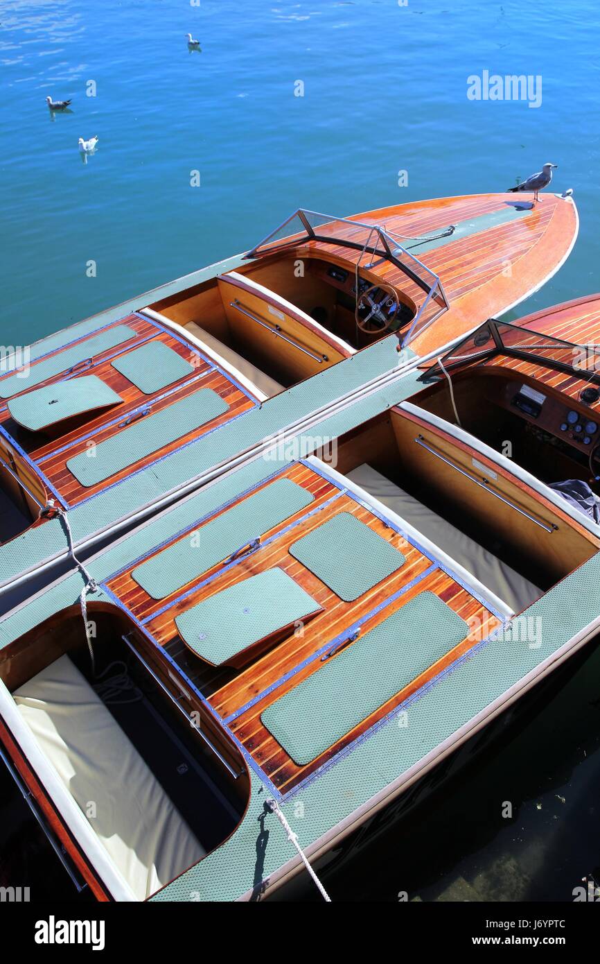 Two classic wooden speedboats moored in blue water ready to take ...