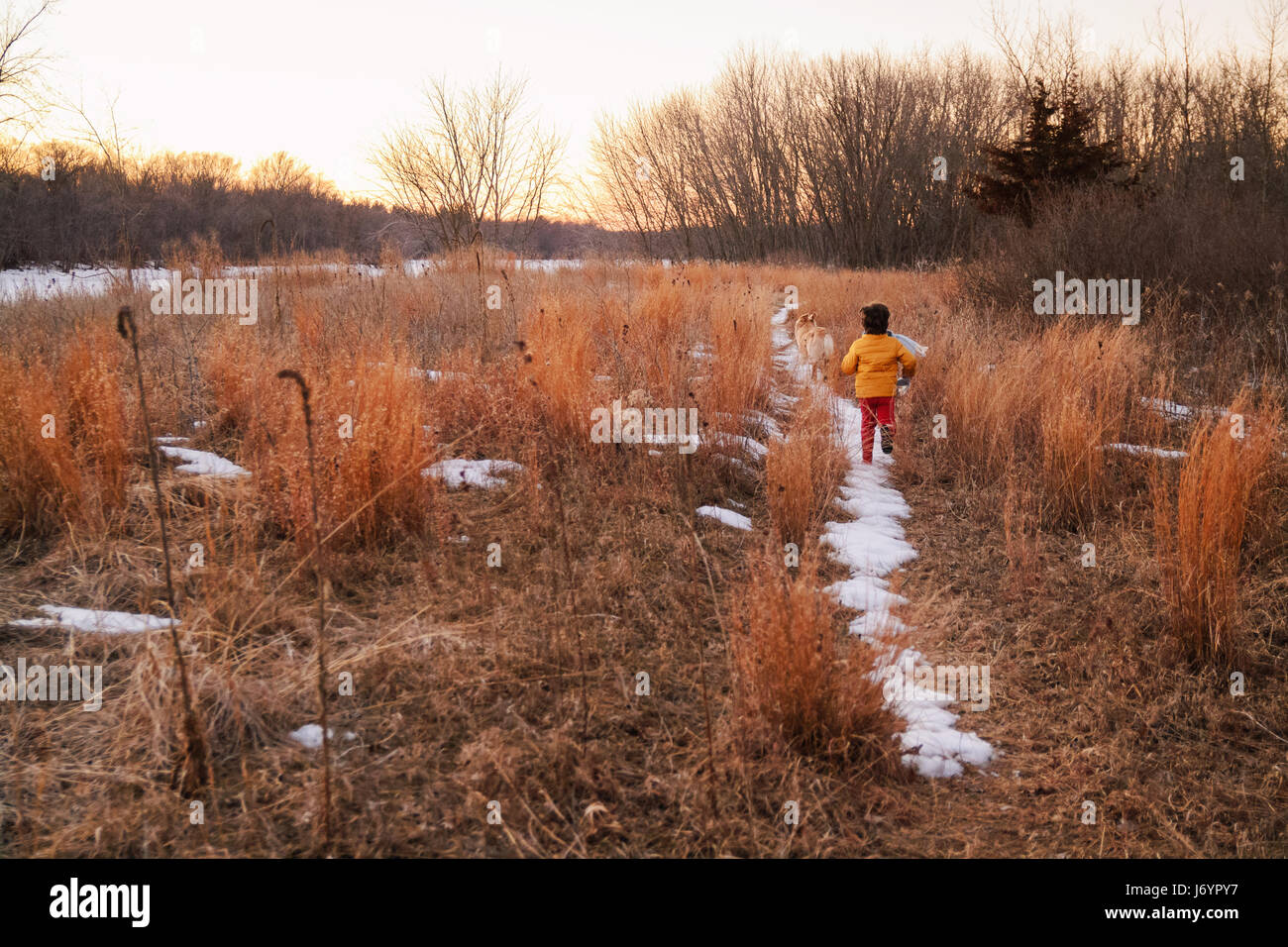 Boy running through rural landscape in winter Stock Photo - Alamy