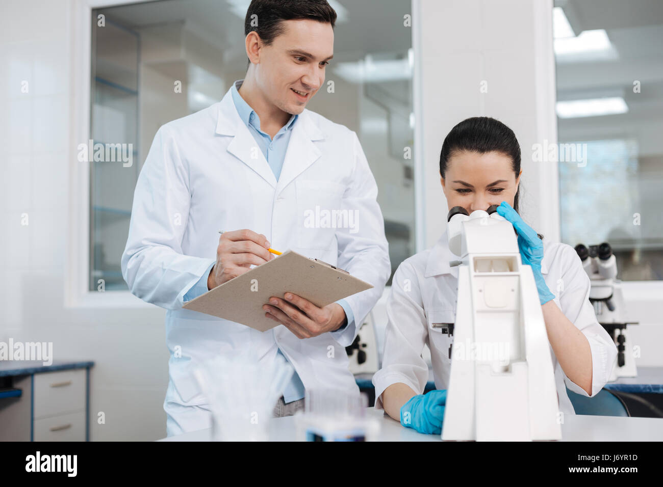 Positive delighted lab assistant holding folder Stock Photo - Alamy