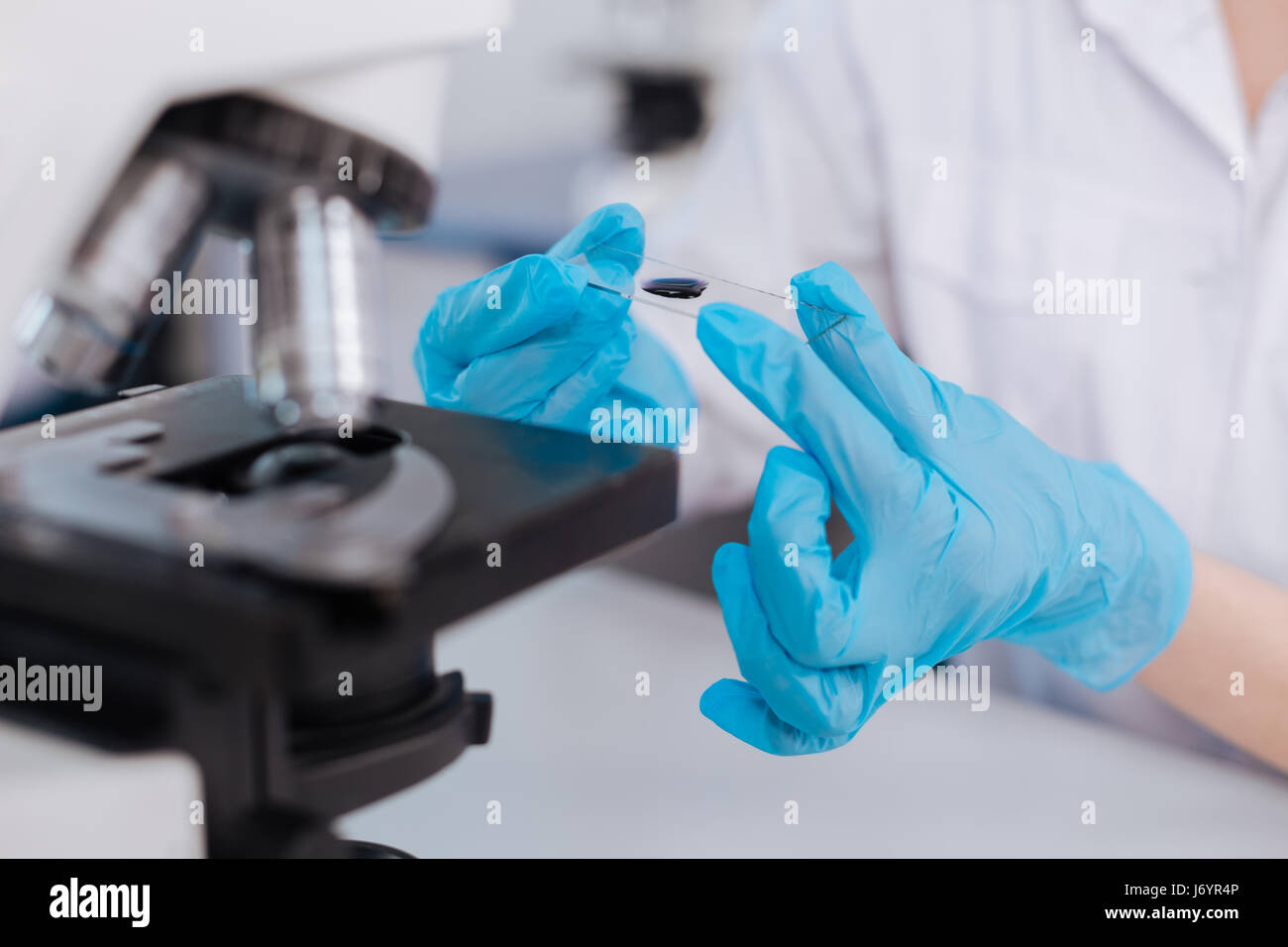 Glass with dark-blue drop being in female hands Stock Photo - Alamy