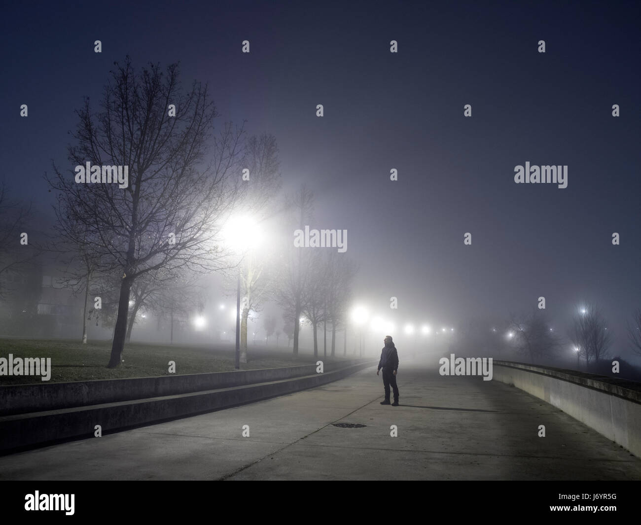 Man standing in street at night Stock Photo - Alamy