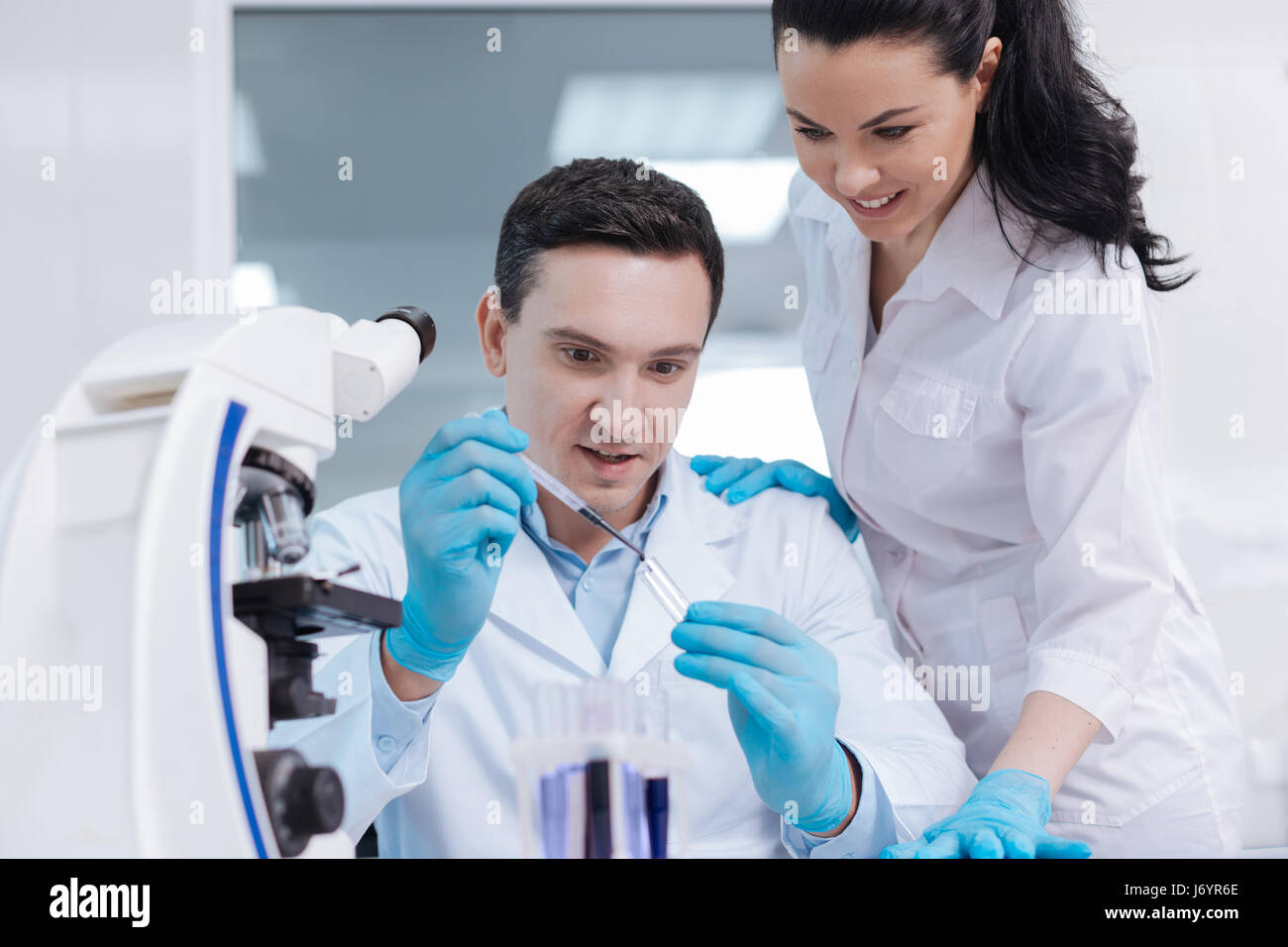 Attractive competent lab assistant standing near her colleague Stock ...
