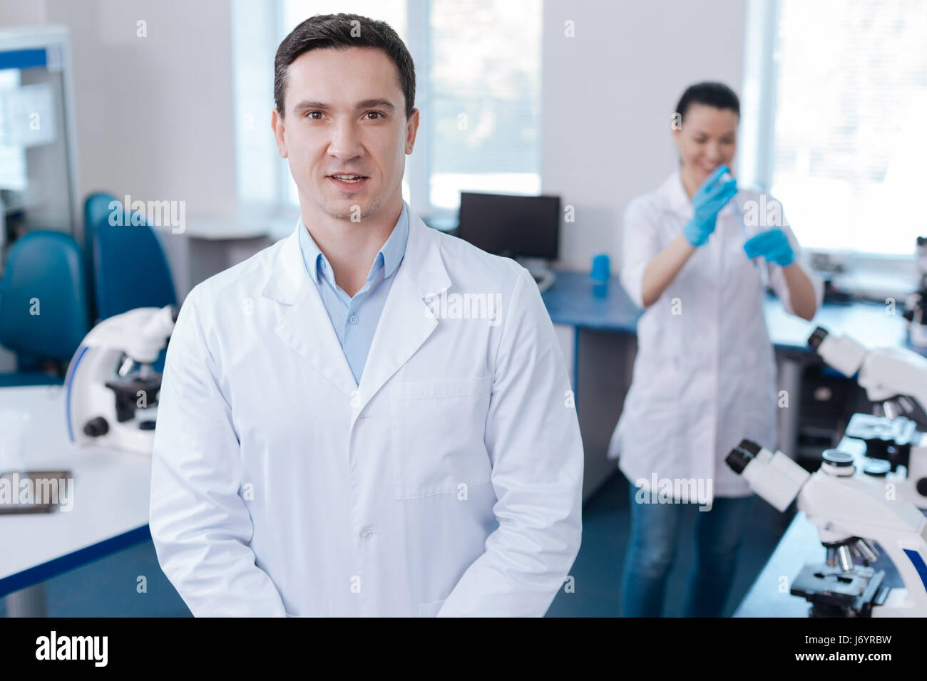 Portrait of serious scientist standing on the foreground Stock Photo ...