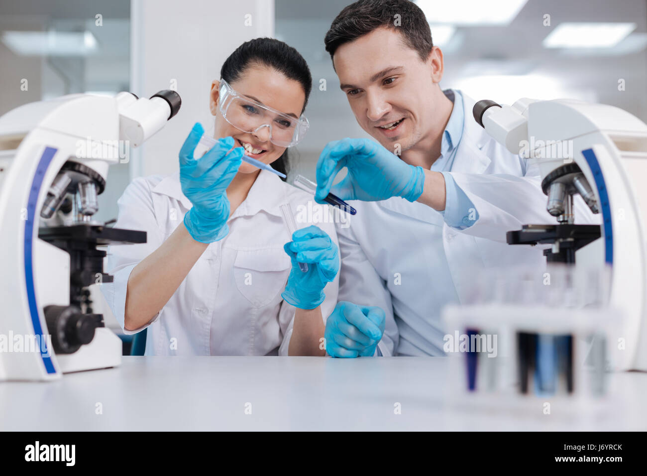 Delighted female researcher taking blue reagent Stock Photo - Alamy
