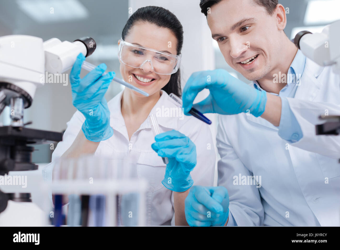 Positive delighted lab assistants testing new reagent Stock Photo - Alamy