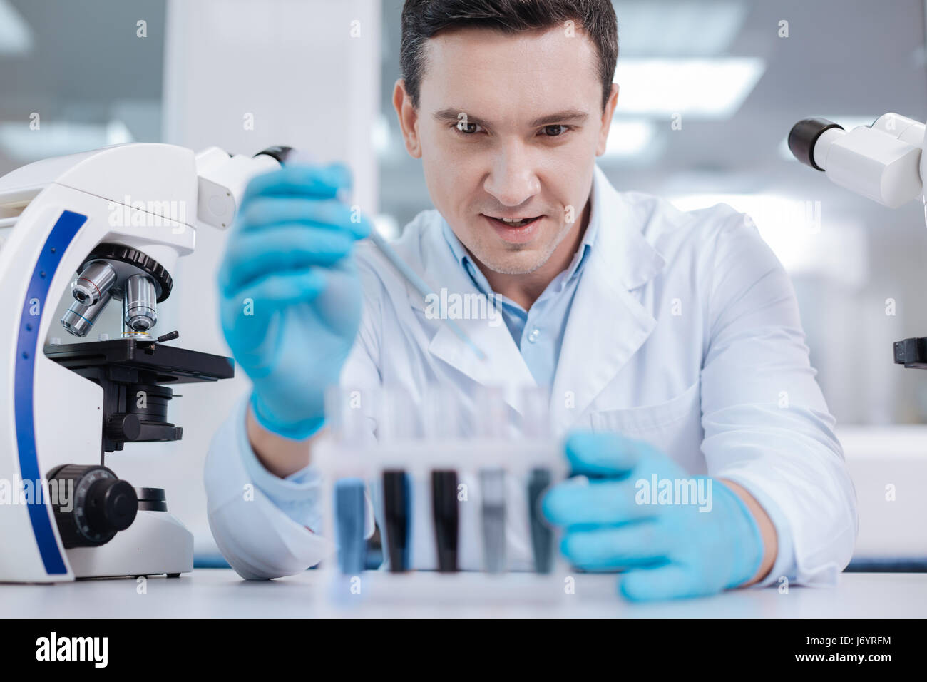 Delighted male person looking at test-tubes Stock Photo - Alamy