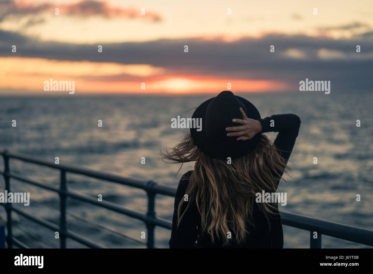 Woman looking at sunset, Santa Monica beach, California, United States ...