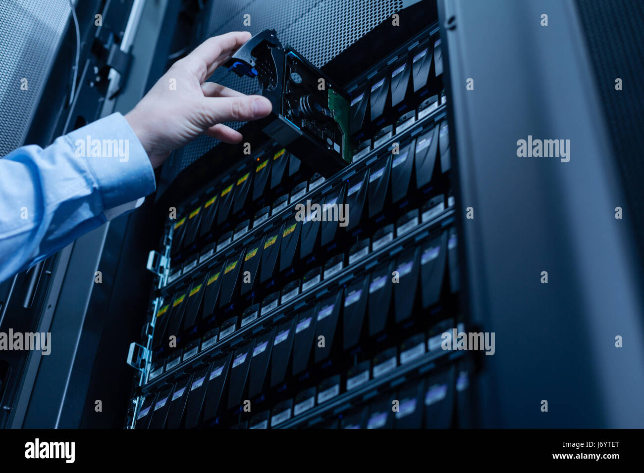 Close up of a hard drive being put into server rack Stock Photo - Alamy
