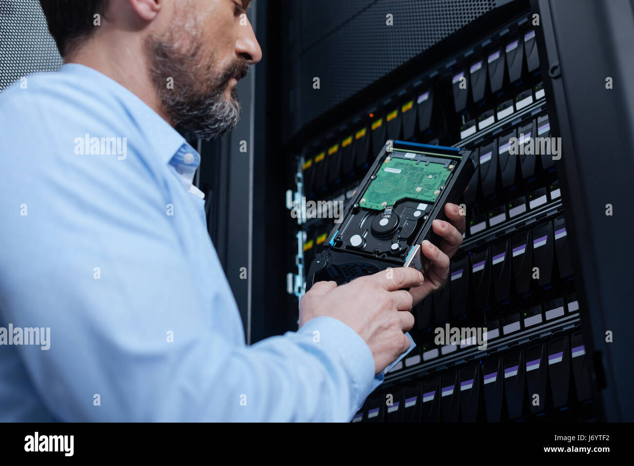 Handsome serious man examining a hard drive Stock Photo - Alamy
