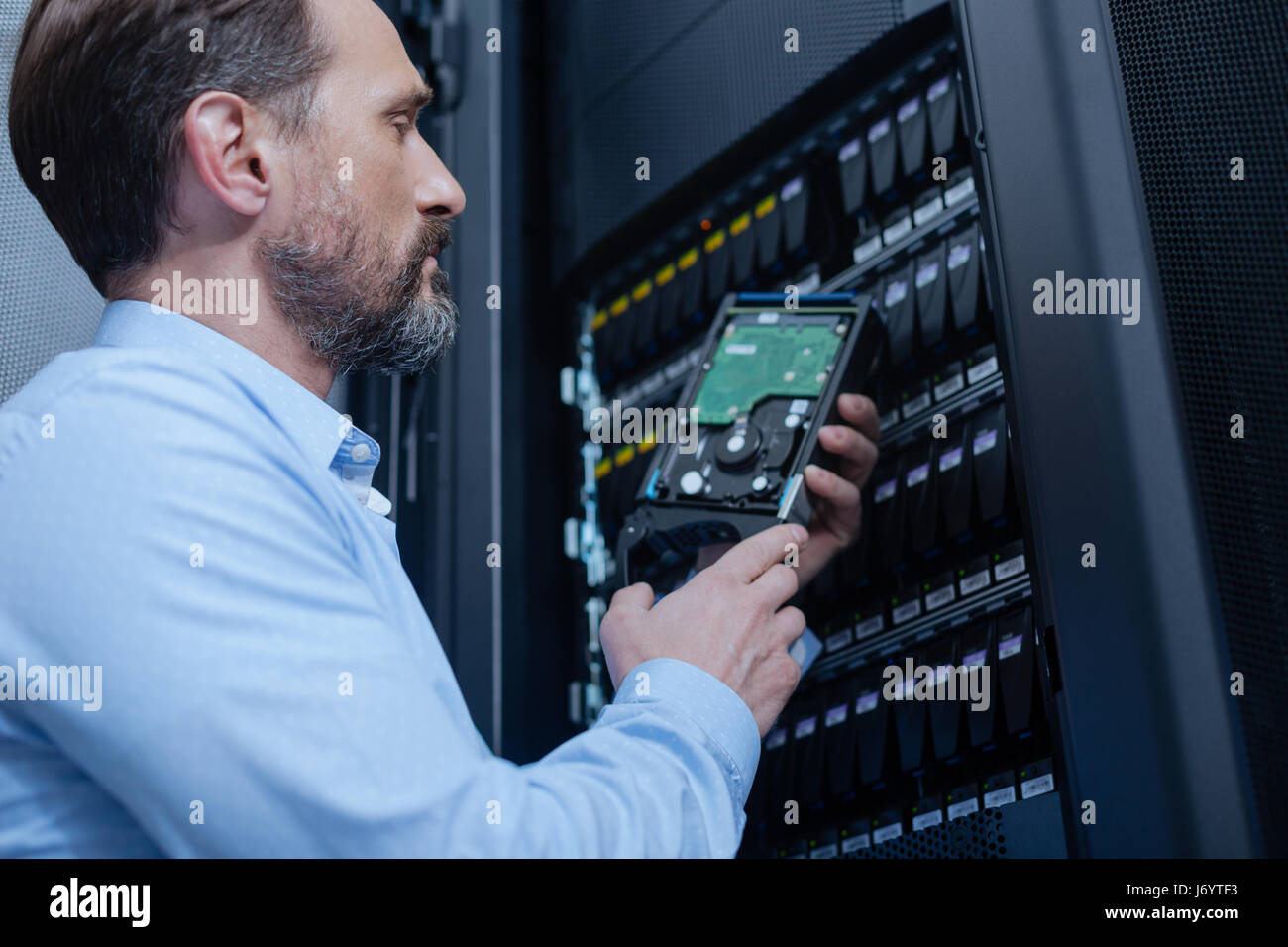 Hard working serious man holding a hard drive Stock Photo - Alamy