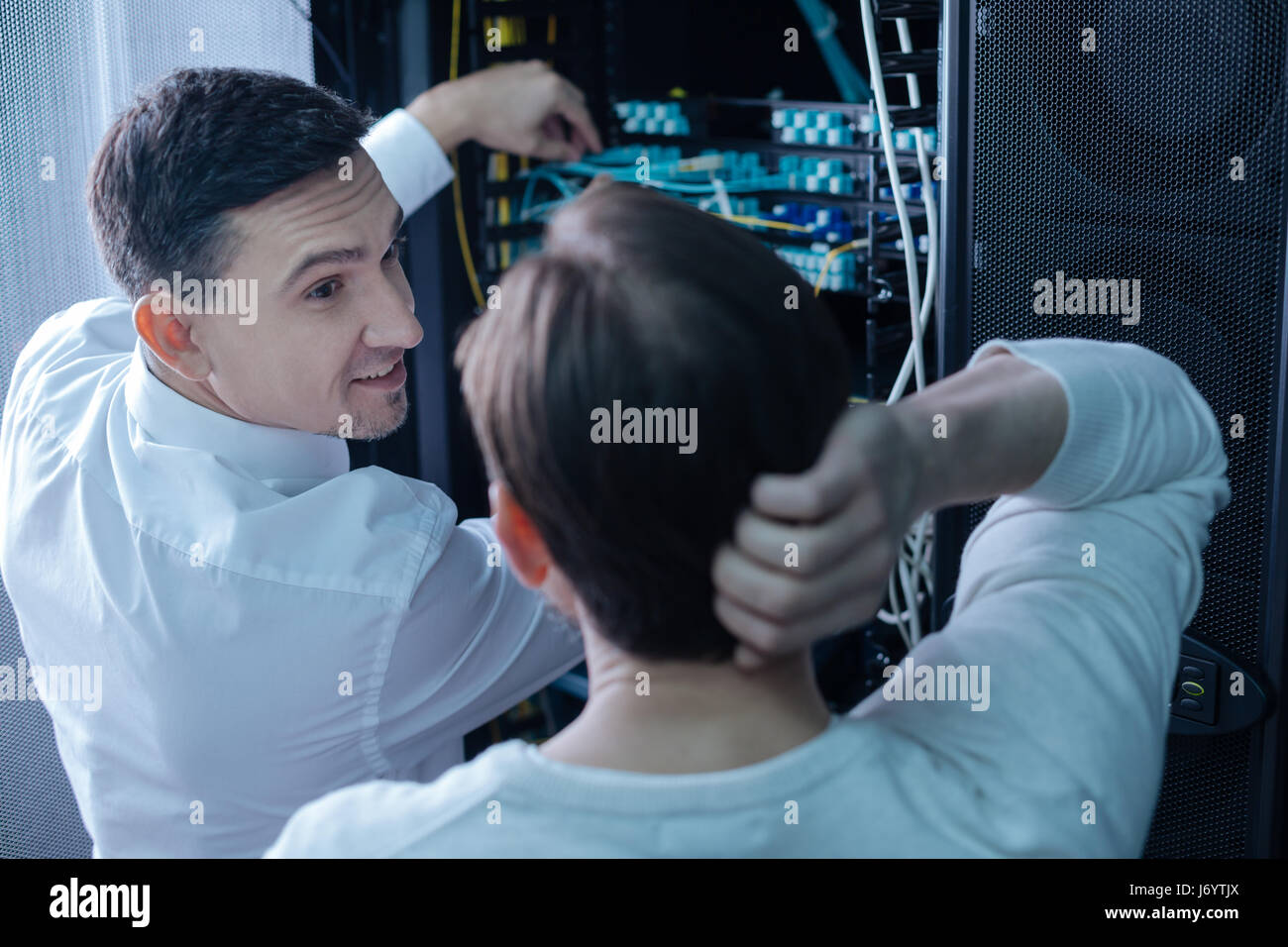 Nice pleasant man scratching his forehead Stock Photo - Alamy