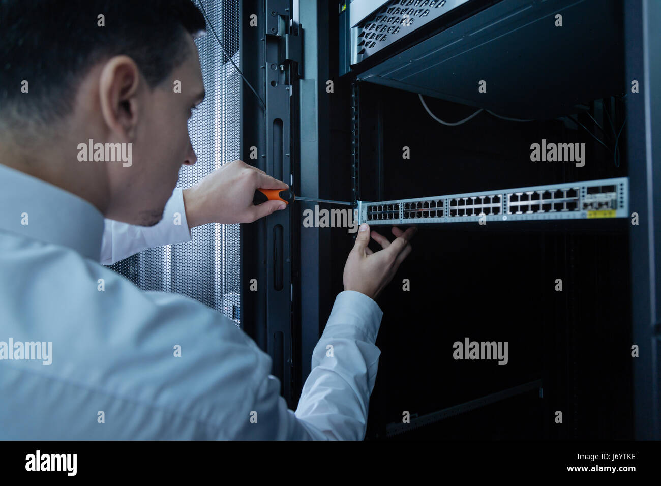 Handsome professional engineer holding a screwdriver Stock Photo - Alamy