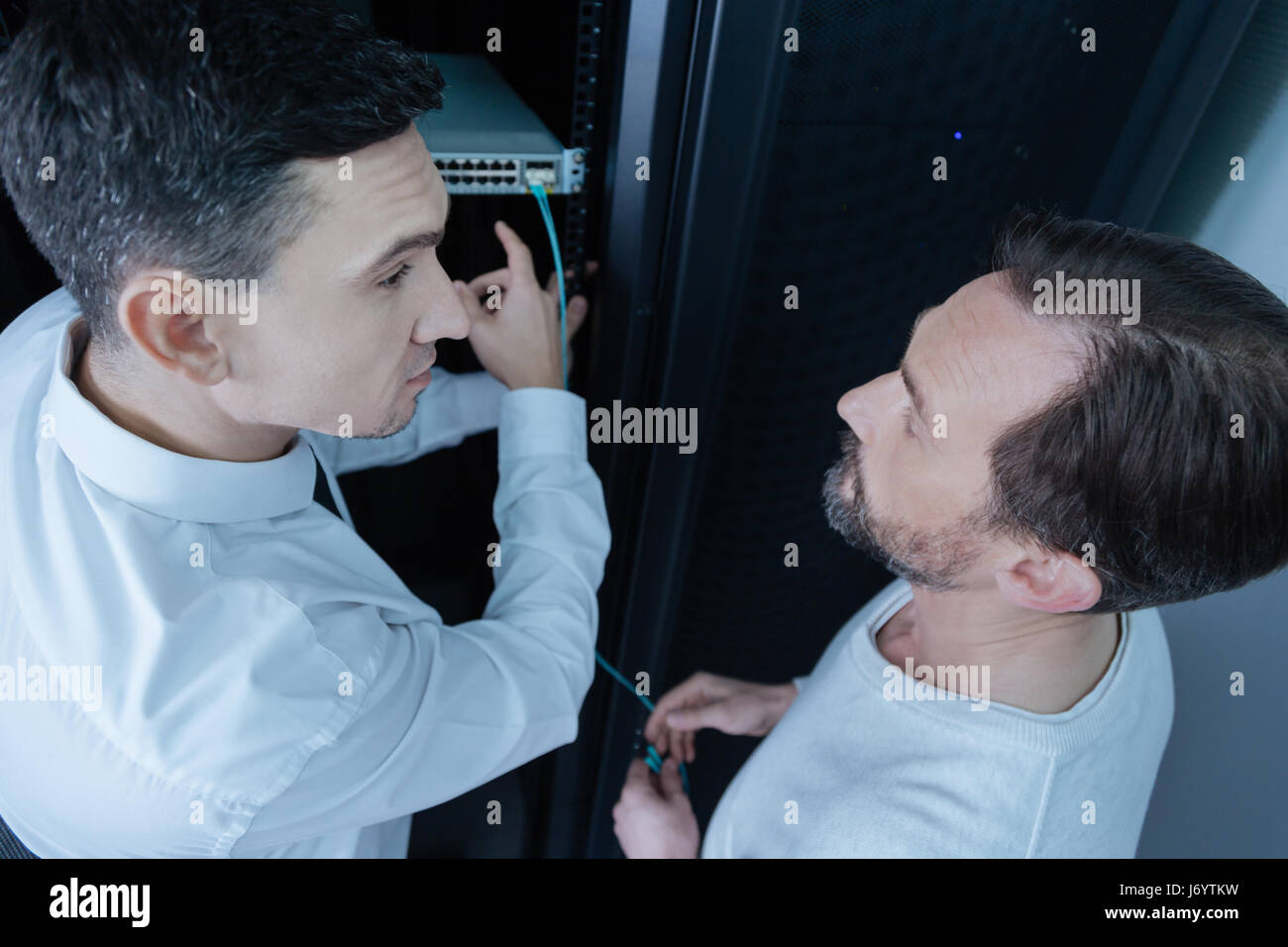 Handsome positive man pointing at the rack server Stock Photo - Alamy