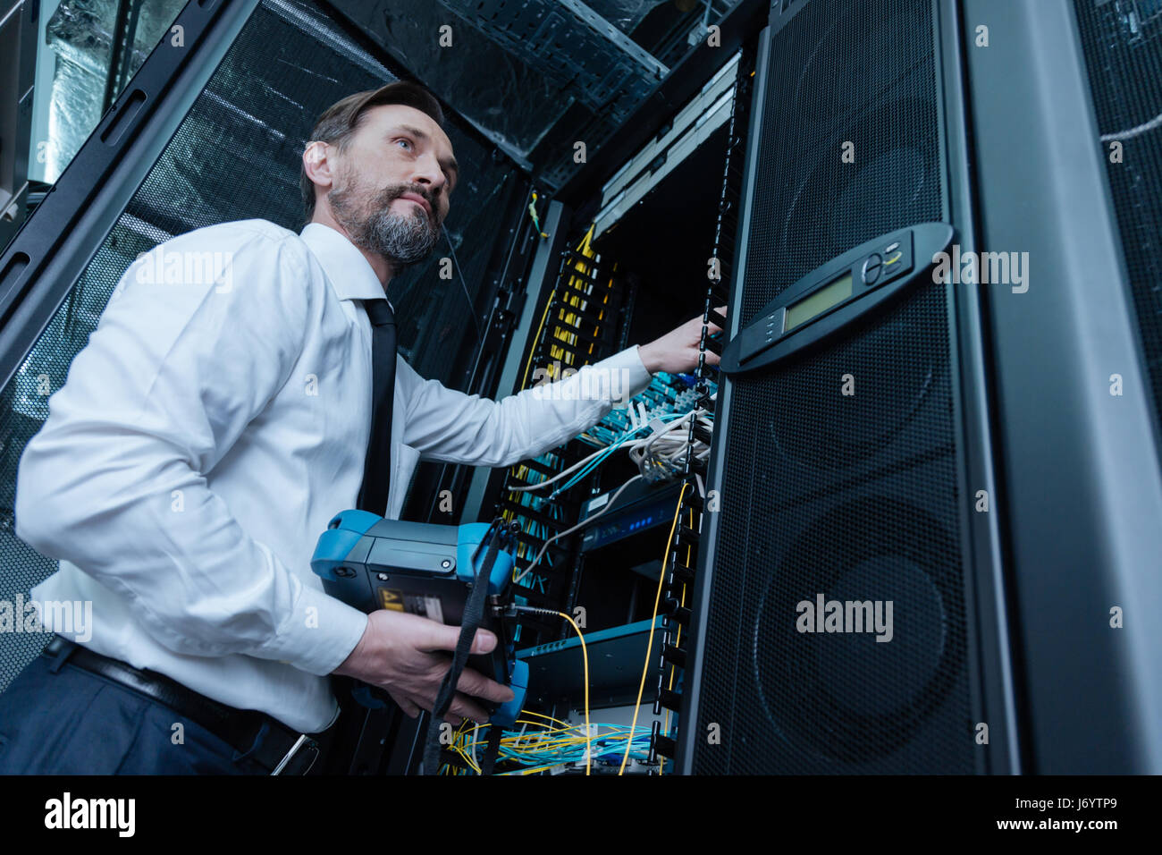 Handsome professional technician repairing the network server Stock ...