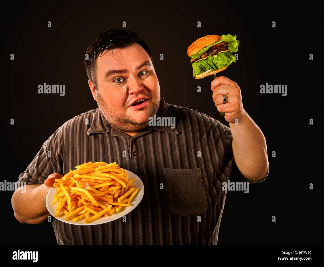 Fat man eating fast food hamberger. Breakfast for overweight person ...